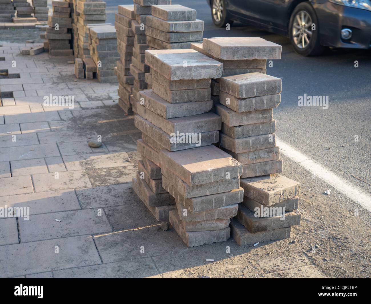 A stack of pavers tiles on the ground. Road works. Laying tiles on the ...