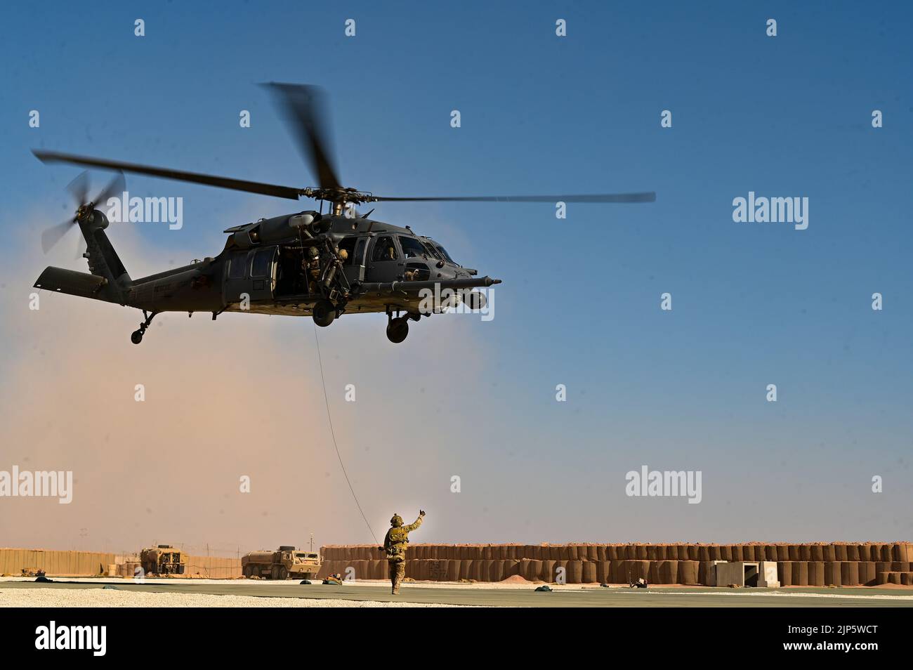 A U.S. Air Force pararescuemen, assigned to the 52nd Expeditionary Rescue Squadron waves to be ...