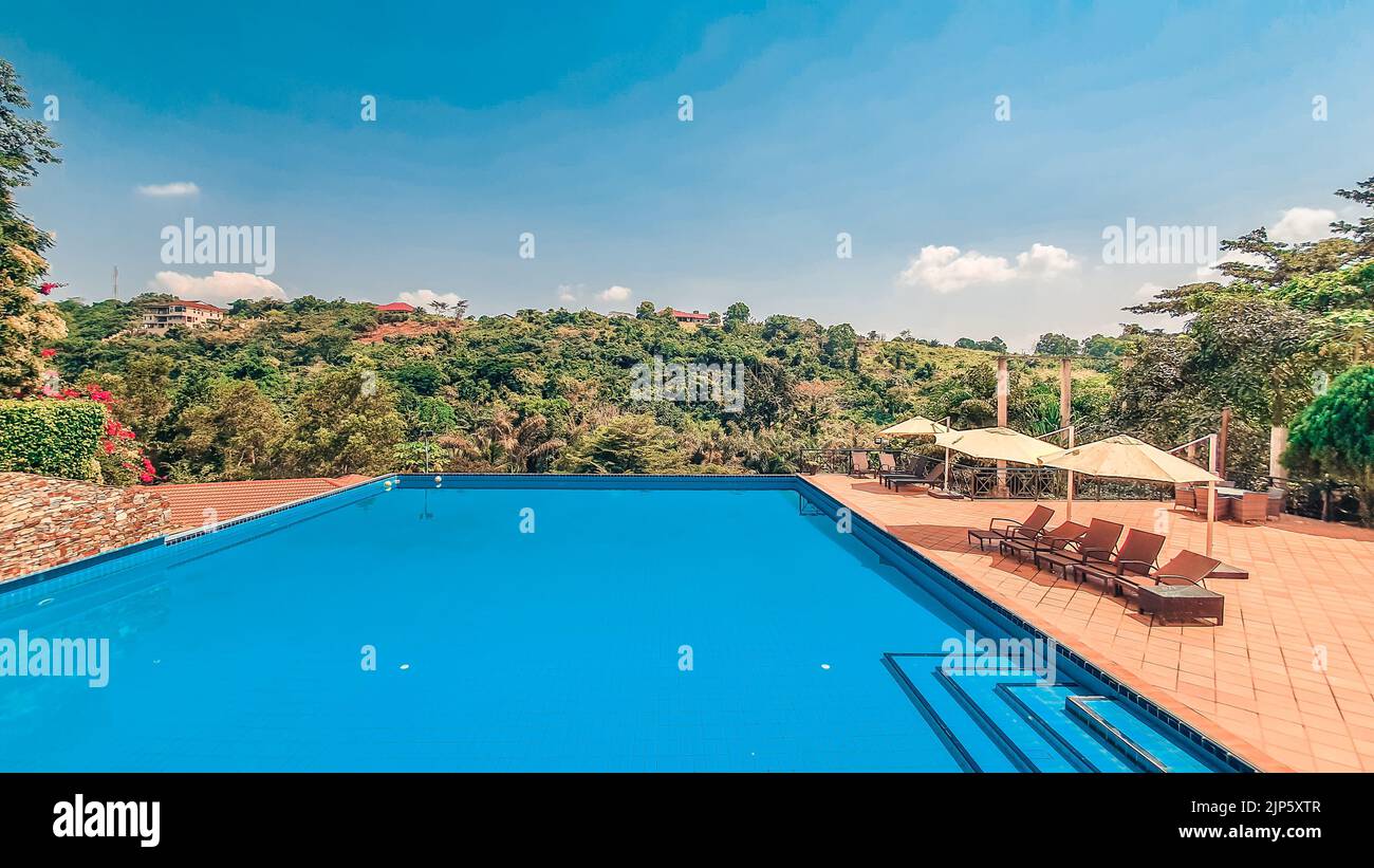 A big rectangular swimming pool surrounded with umbrellas and ...