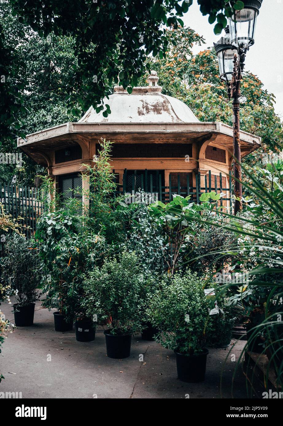 A vertical shot of an outdoor plant shop with circular cute building in ...
