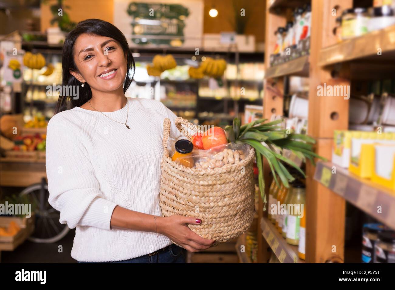 Satisfied hispanic woman with purchases in supermarket Stock Photo - Alamy