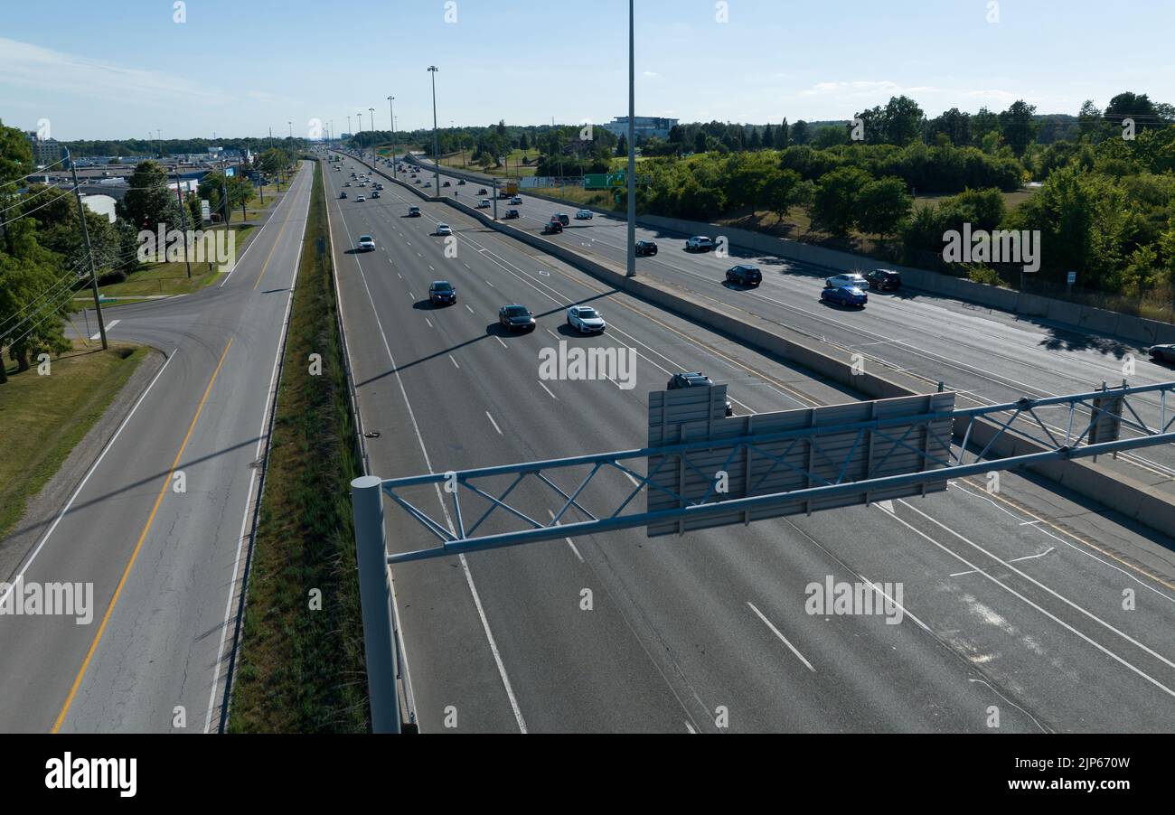 An aerial view above a large, multi-lane highway as traffic pass below ...