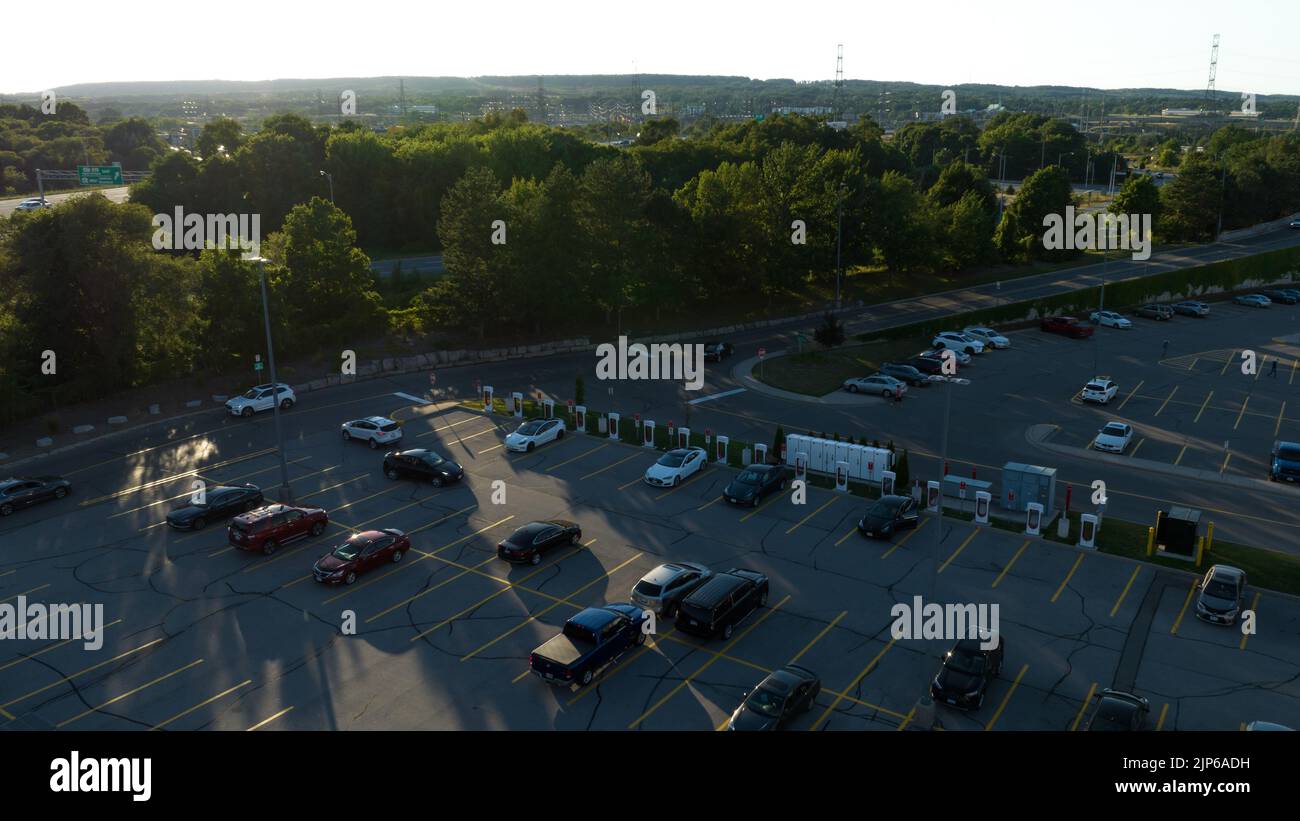 An aerial view looking at a Tesla Supercharger station in a parking lot ...