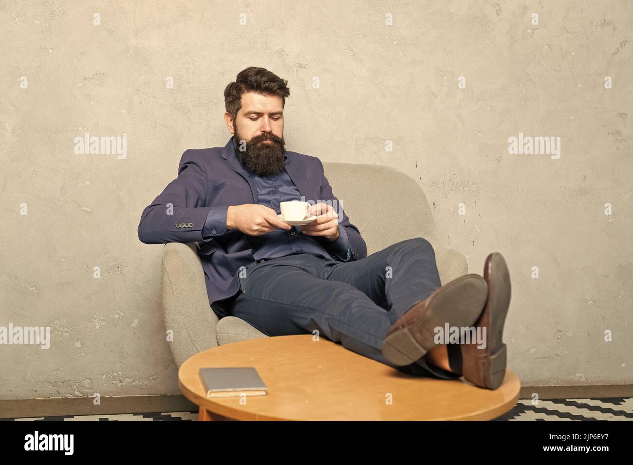 Relaxing guy employee drink tea sitting feet up in rest armchair, tea ...