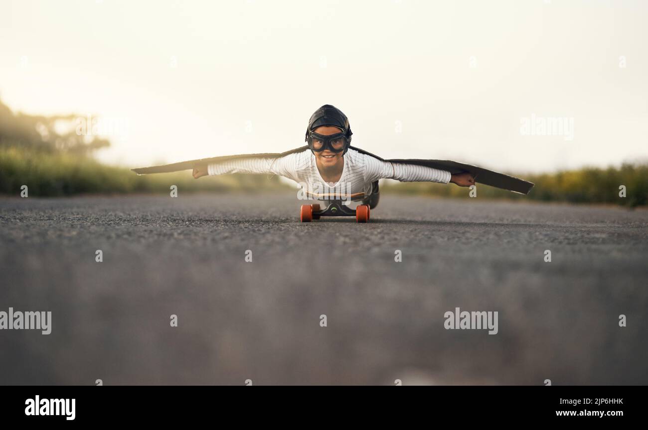 Flying is just a hobby. Portrait of a young boy pretending to fly with ...