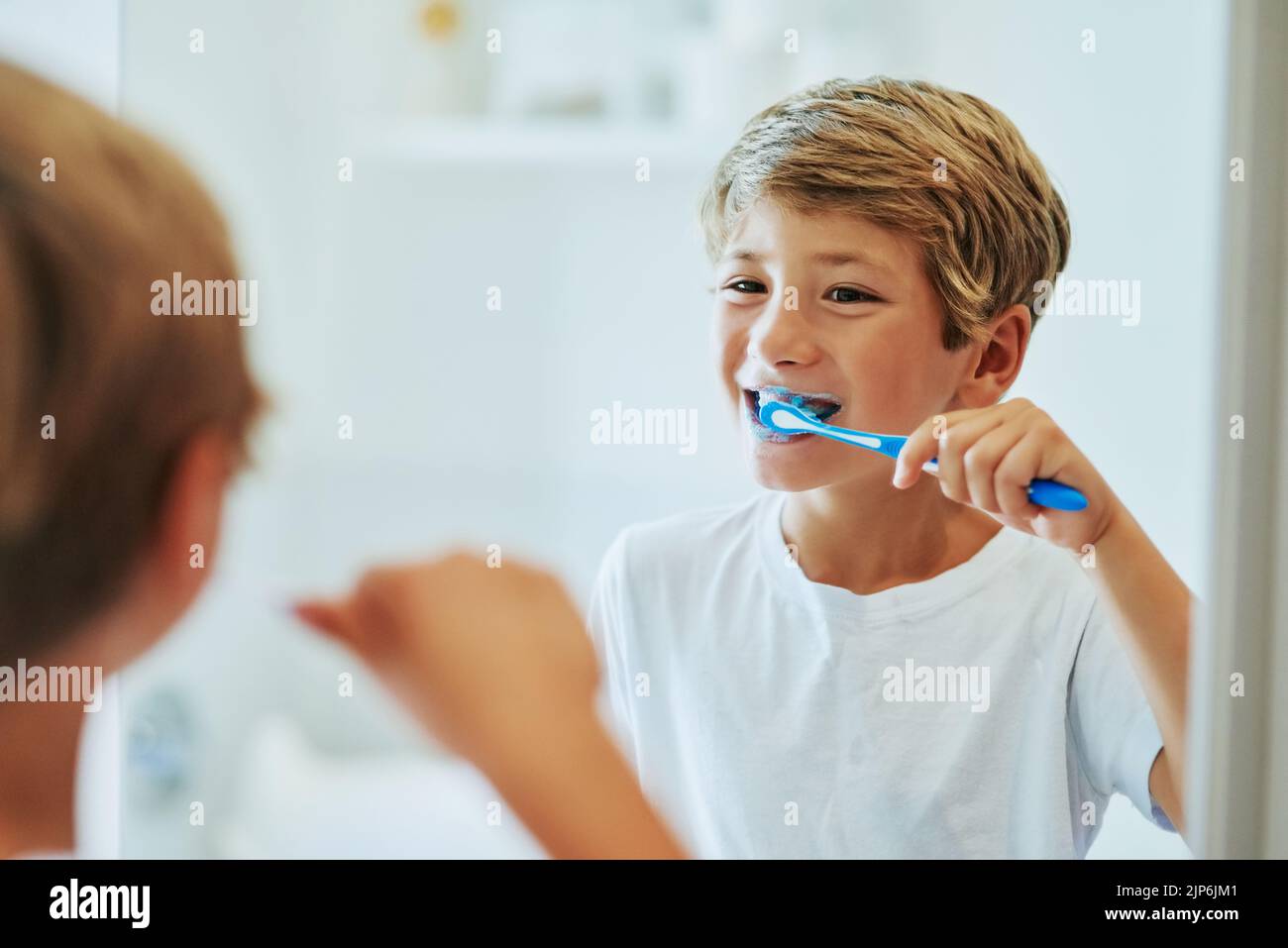 Brushing your teeth is an important routine. a cheerful young boy ...