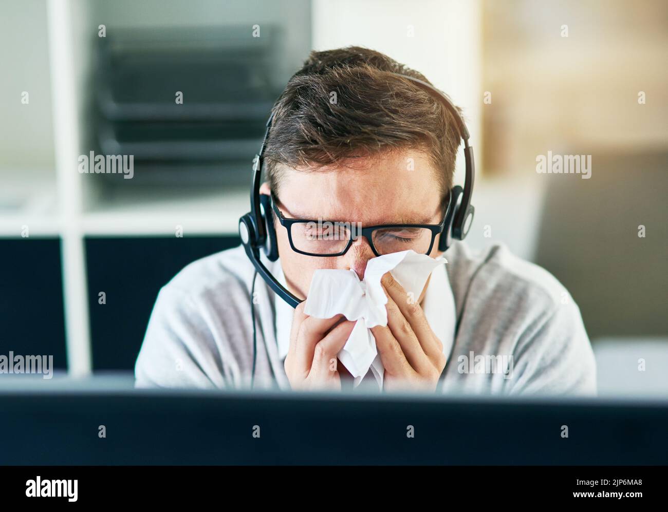 Hope Im not getting sick again. a young call centre agent blowing his ...
