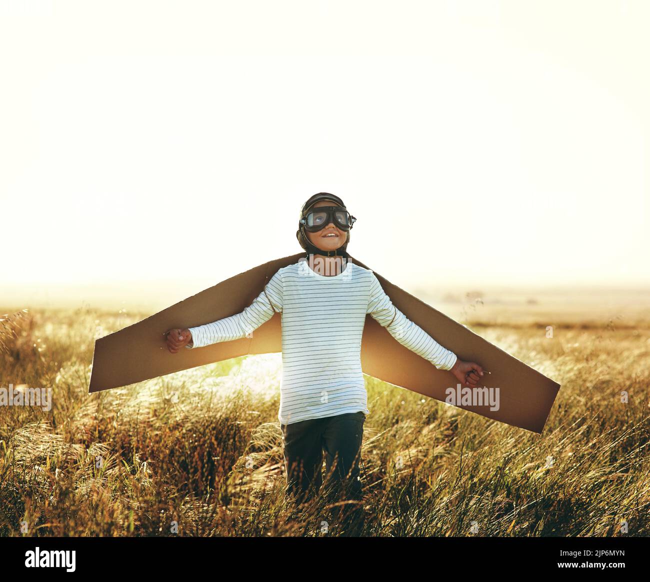 Spread your wings and soar. a young boy pretending to fly with a pair ...