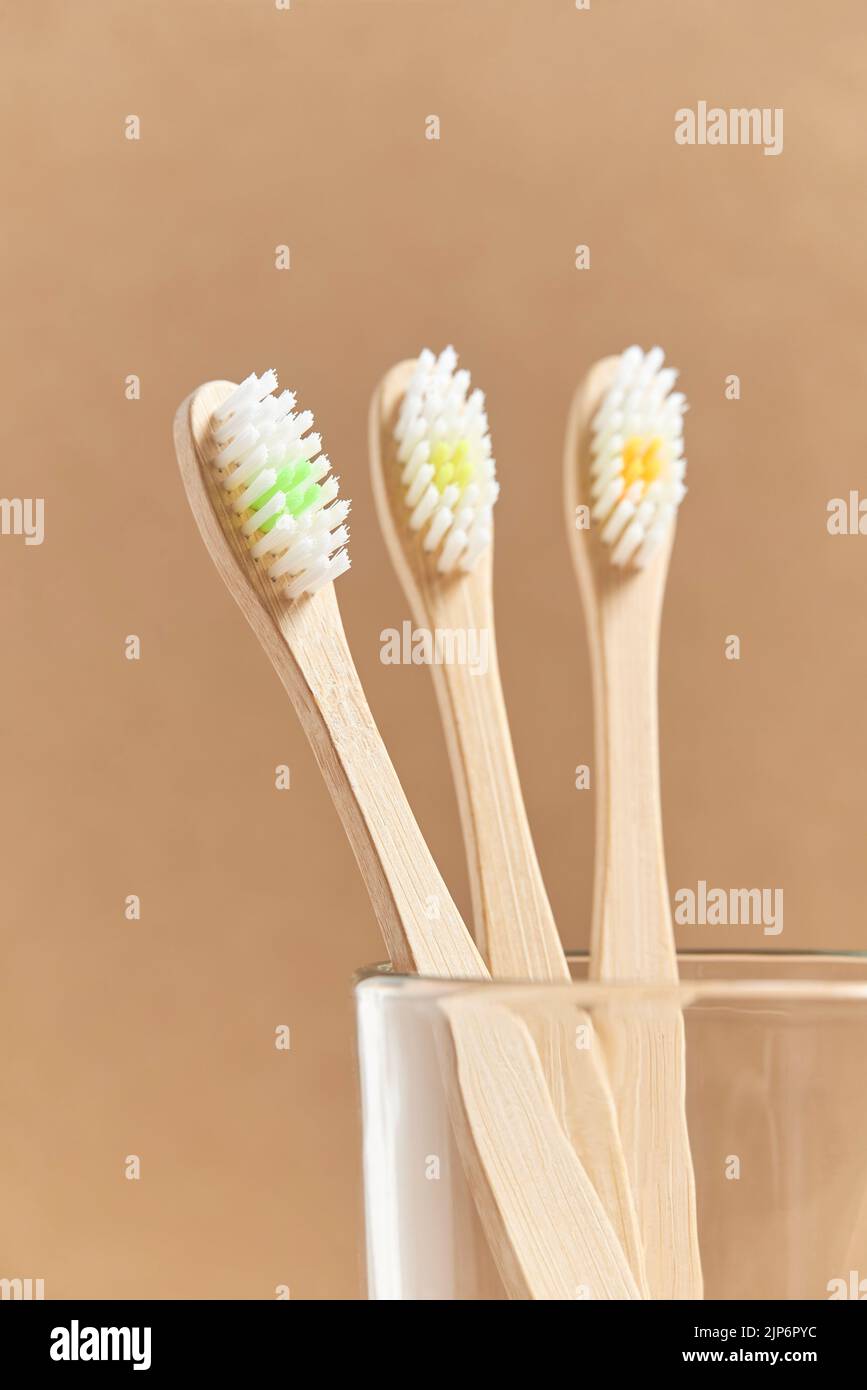 Set of three ecological bamboo toothbrushes in a glass cup. Concepts ...