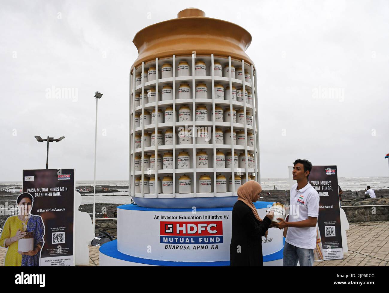 A woman signs on a Barni (glass jar) as a pledge during a campaign ...