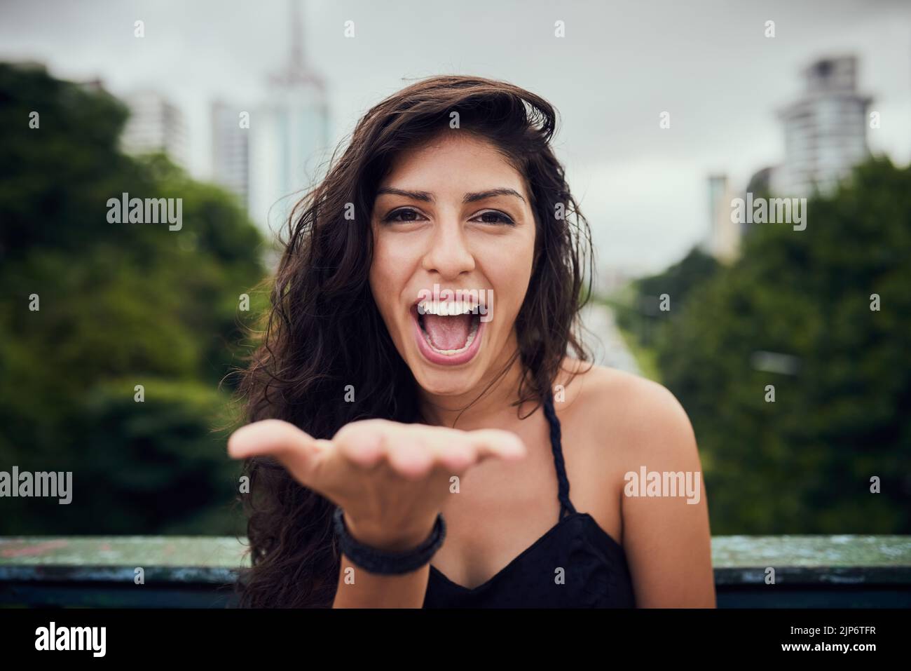 Just for you. Portrait of an attractive young woman blowing a kiss out ...