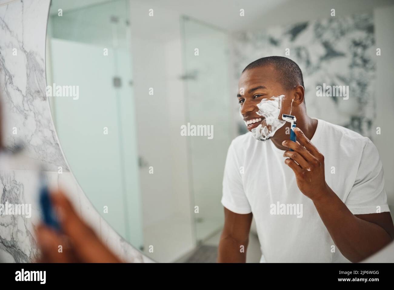 Hes not a fan of the face fuzz. a handsome young man shaving his facial ...