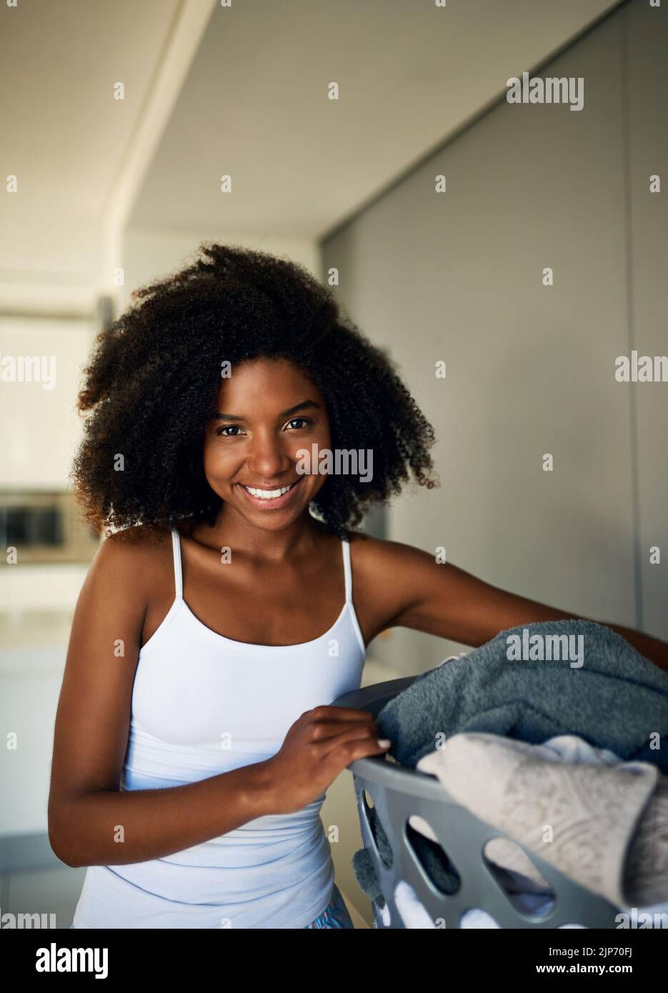Today is laundry day. an attractive young woman doing the laundry at ...