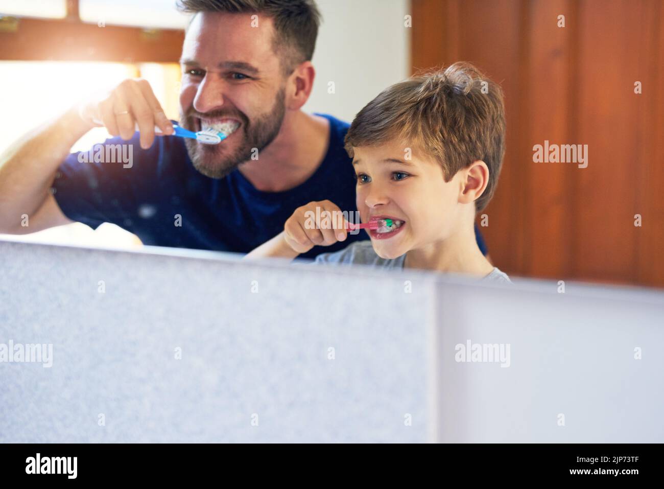 Up, down, round and round. a father and his little son brushing their ...