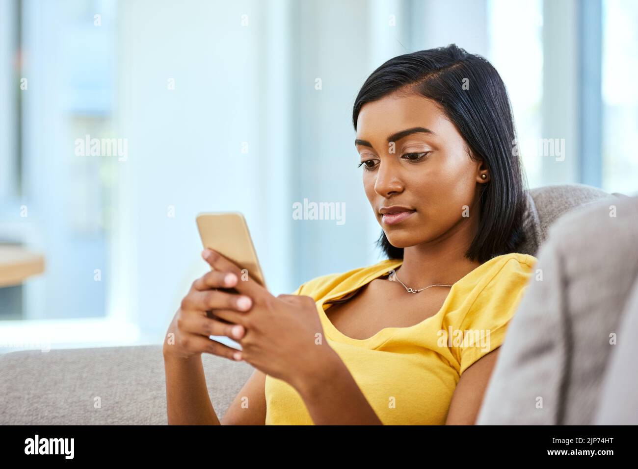 Texting friends and making plans. a teenage girl using a cellphone at ...