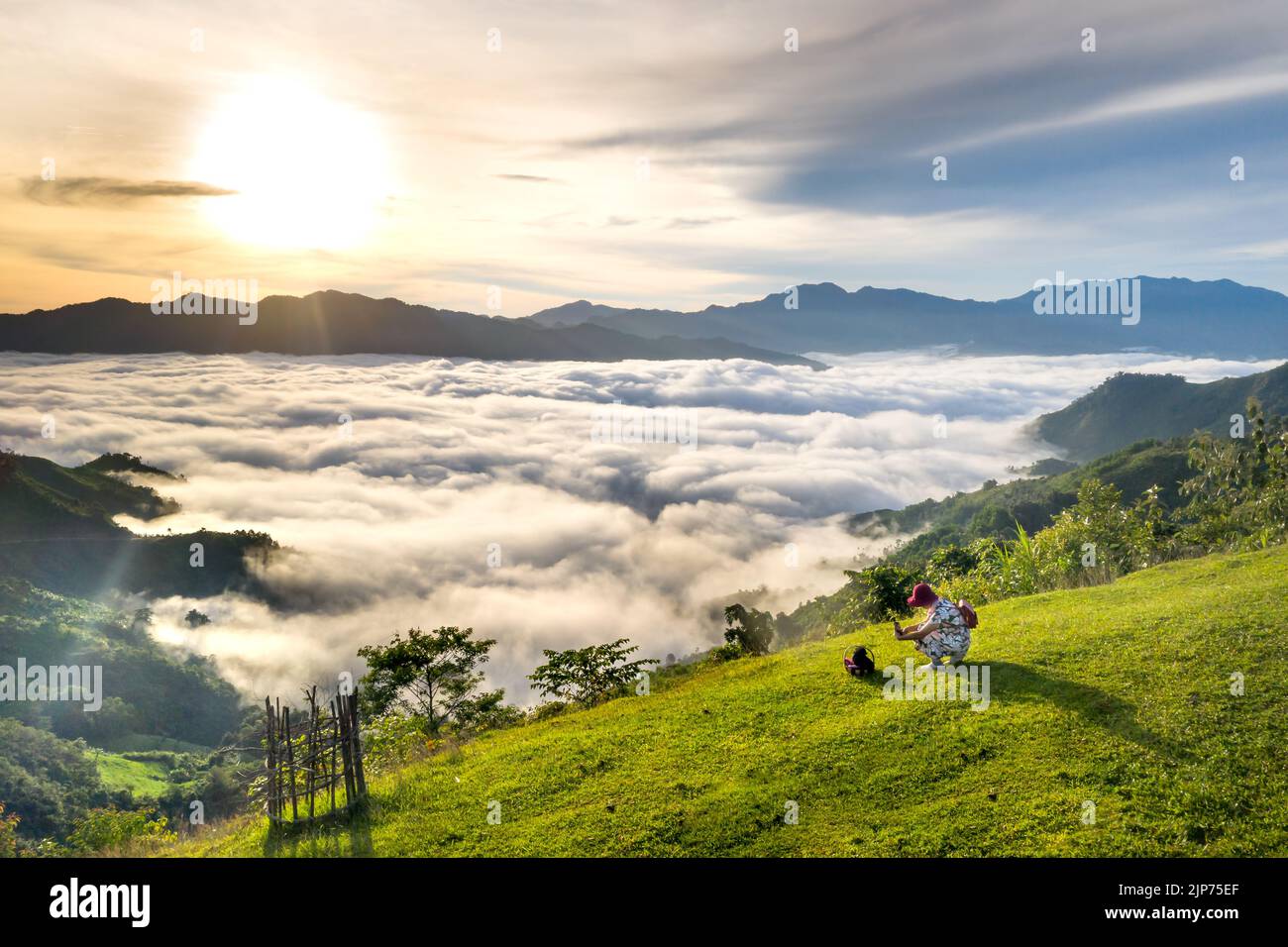 A female tourist looks at the valley full of white clouds in the Tak Po ...