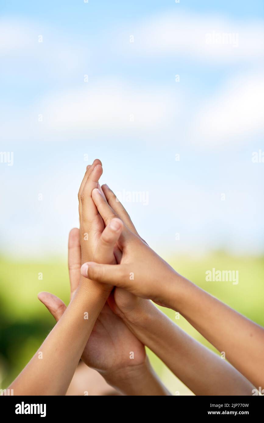 This one is for the kids. a group of children giving each other a high ...