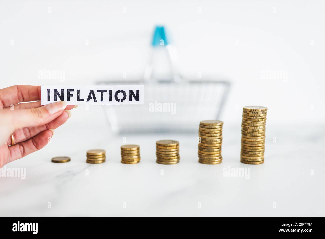 inflation text in front of shopping basket and growing stacks of coins ...