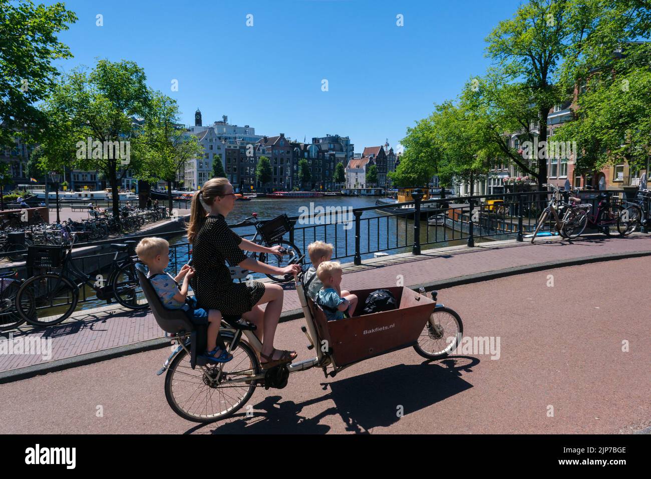 Amsterdam, The Netherlands - 22 June 2022: Mother with kids riding bike ...