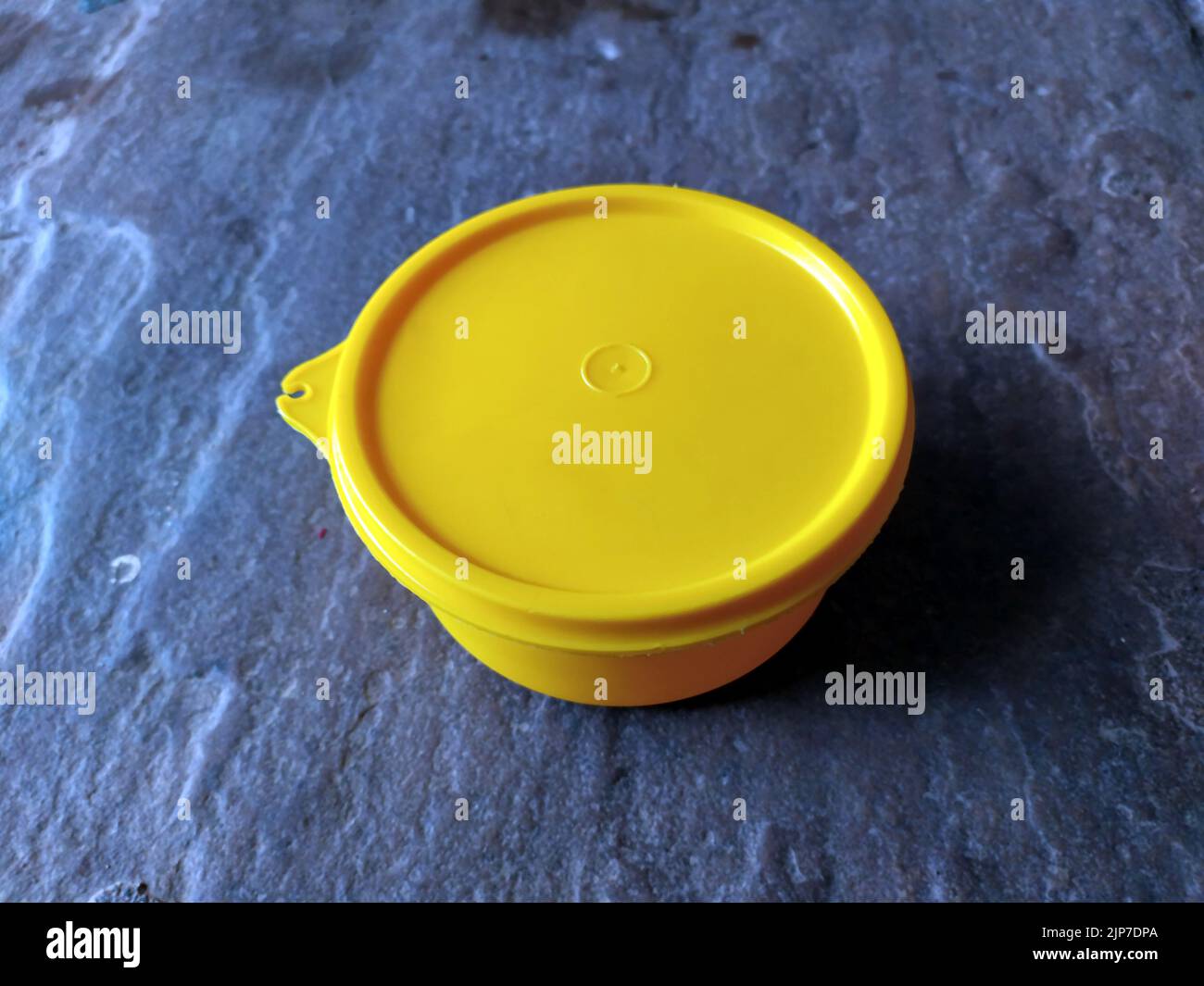 yellow plastic container box on stone background Stock Photo - Alamy