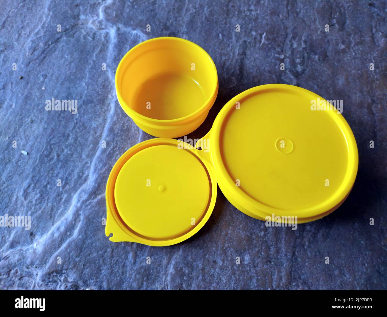 yellow plastic container box on stone background Stock Photo - Alamy
