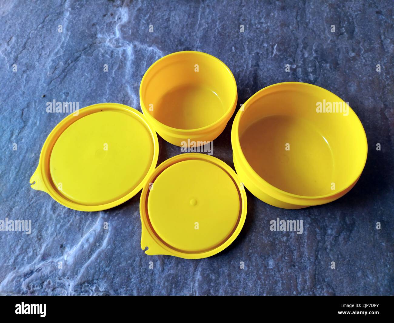 yellow plastic container box on stone background Stock Photo - Alamy
