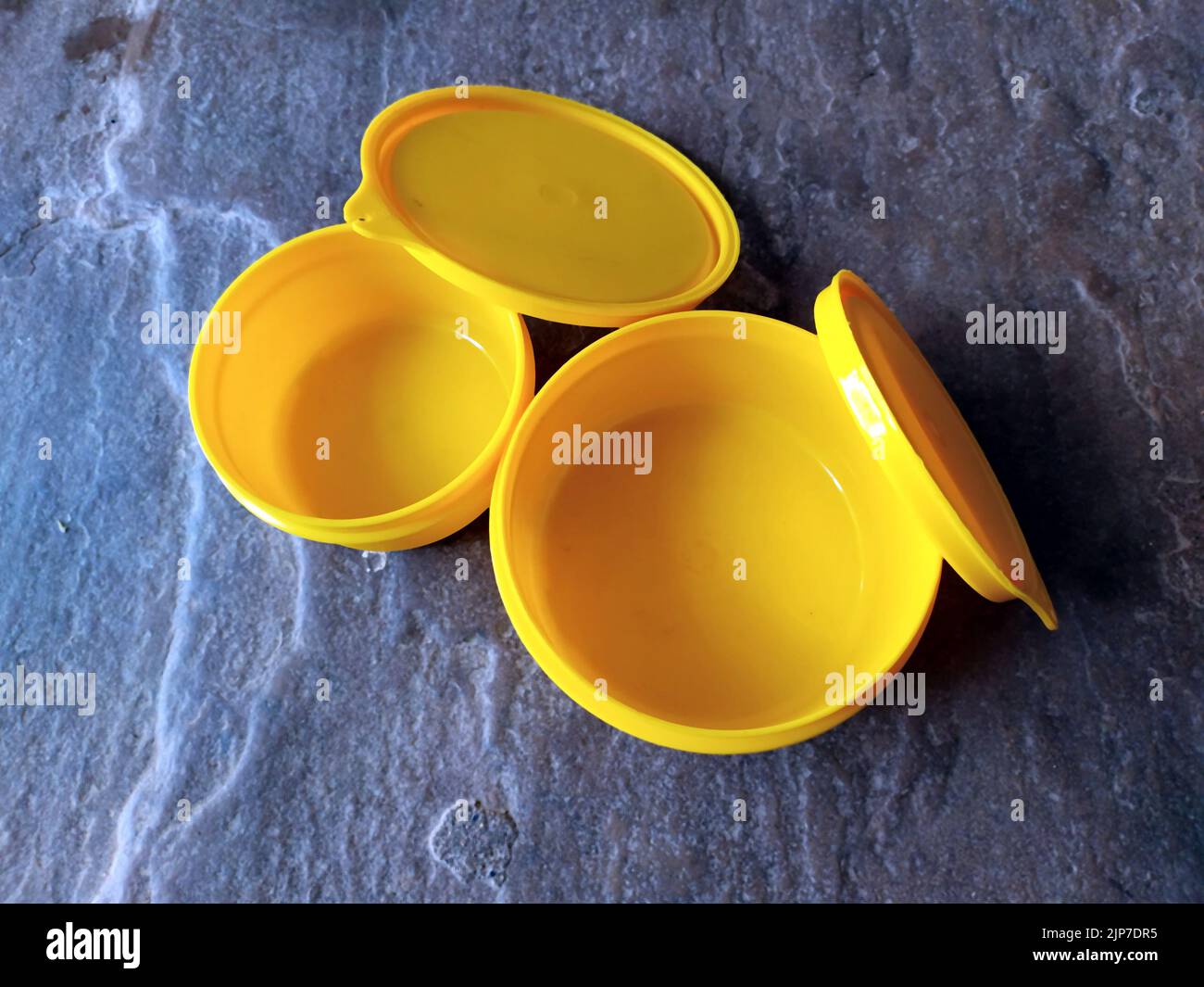 yellow plastic container box on stone background Stock Photo - Alamy