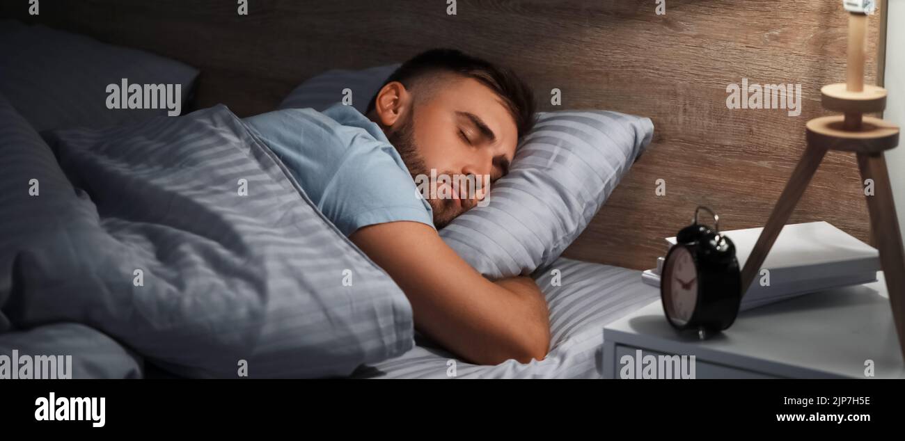 Young man sleeping in bed at night Stock Photo - Alamy