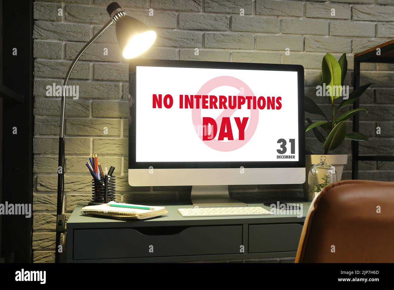 Text NO INTERRUPTIONS DAY on screen of computer monitor at workplace in ...