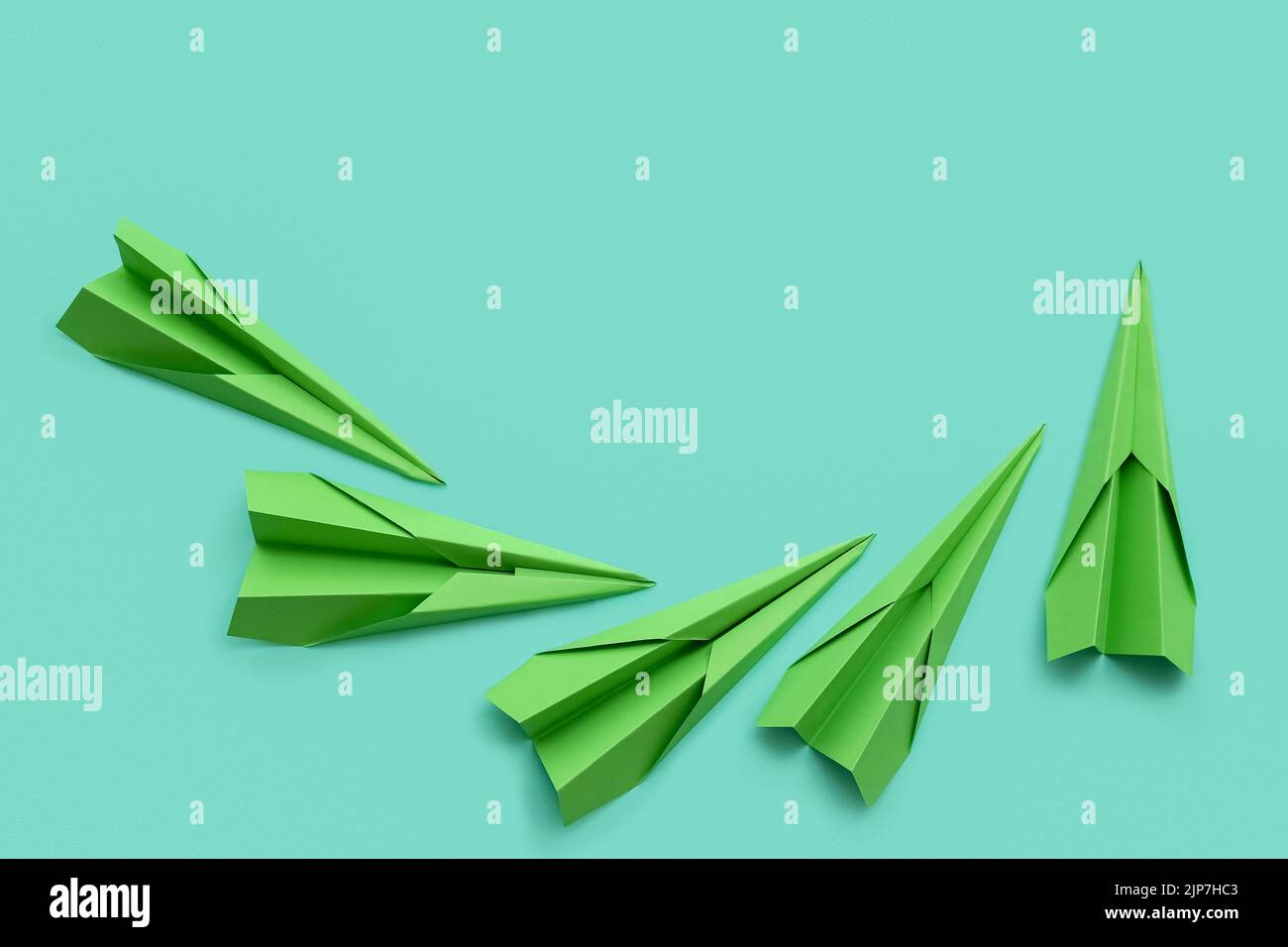 Green paper planes on color background Stock Photo - Alamy