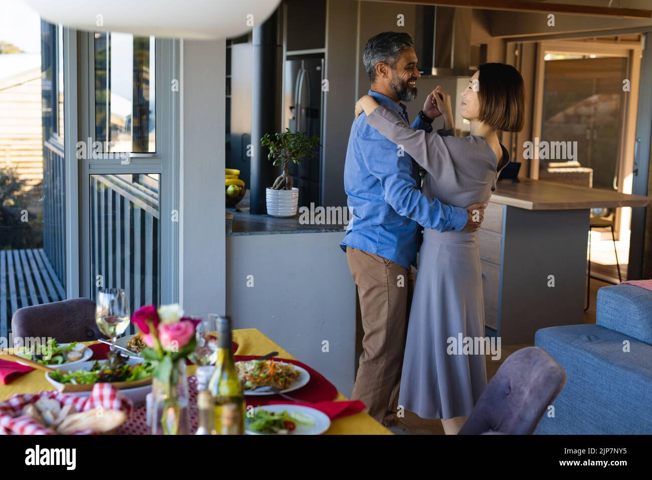 Happy diverse couple dancing together and smiling in dining room Stock ...