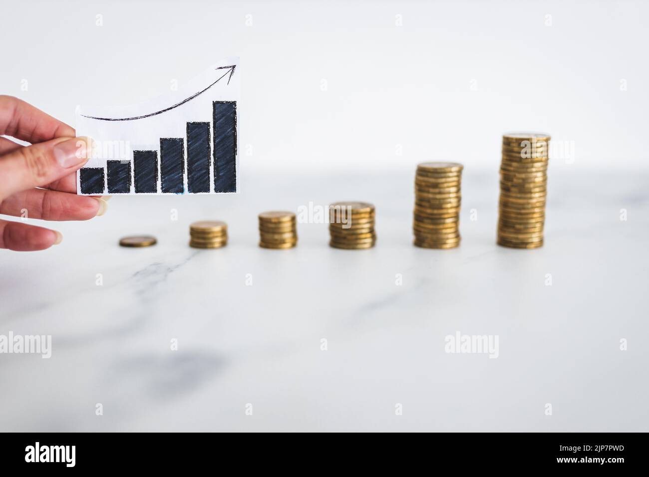 rising inflation graph in front of growing stacks of coins representing ...