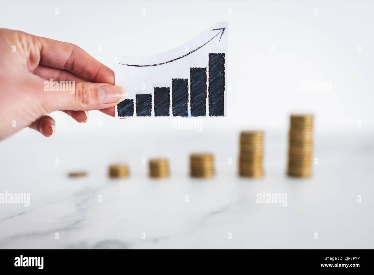 rising inflation graph in front of growing stacks of coins representing ...