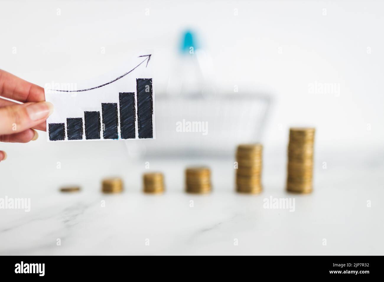 rising inflation graph in front of shopping basket and growing stacks ...