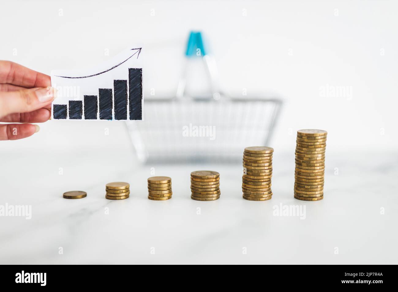 rising inflation graph in front of shopping basket and growing stacks ...