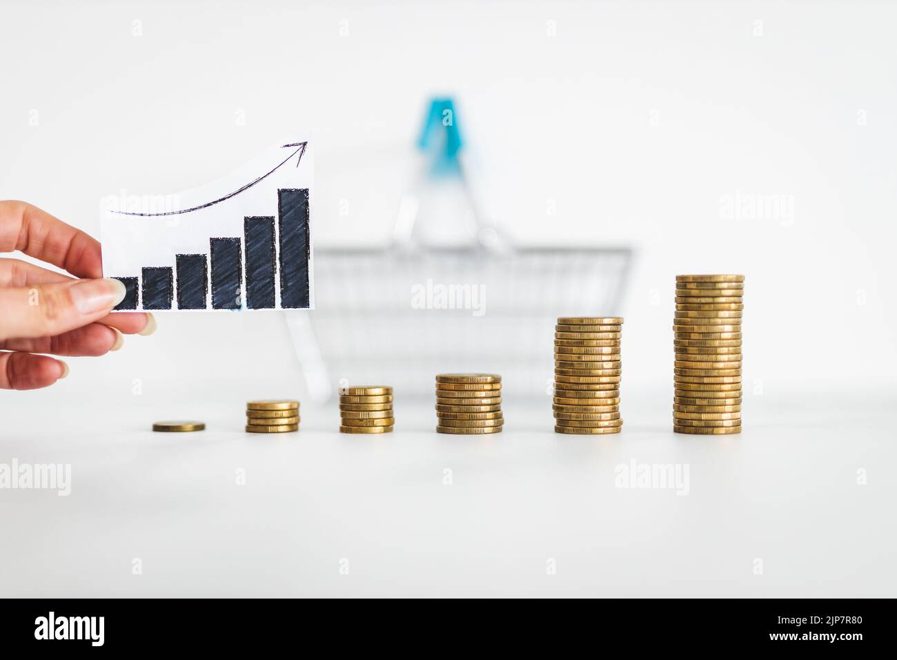 rising inflation graph in front of shopping basket and growing stacks ...