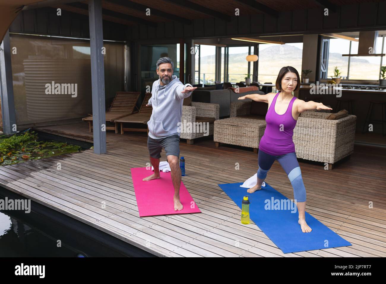 Happy diverse couple doing yoga together, stretching on terrace Stock ...