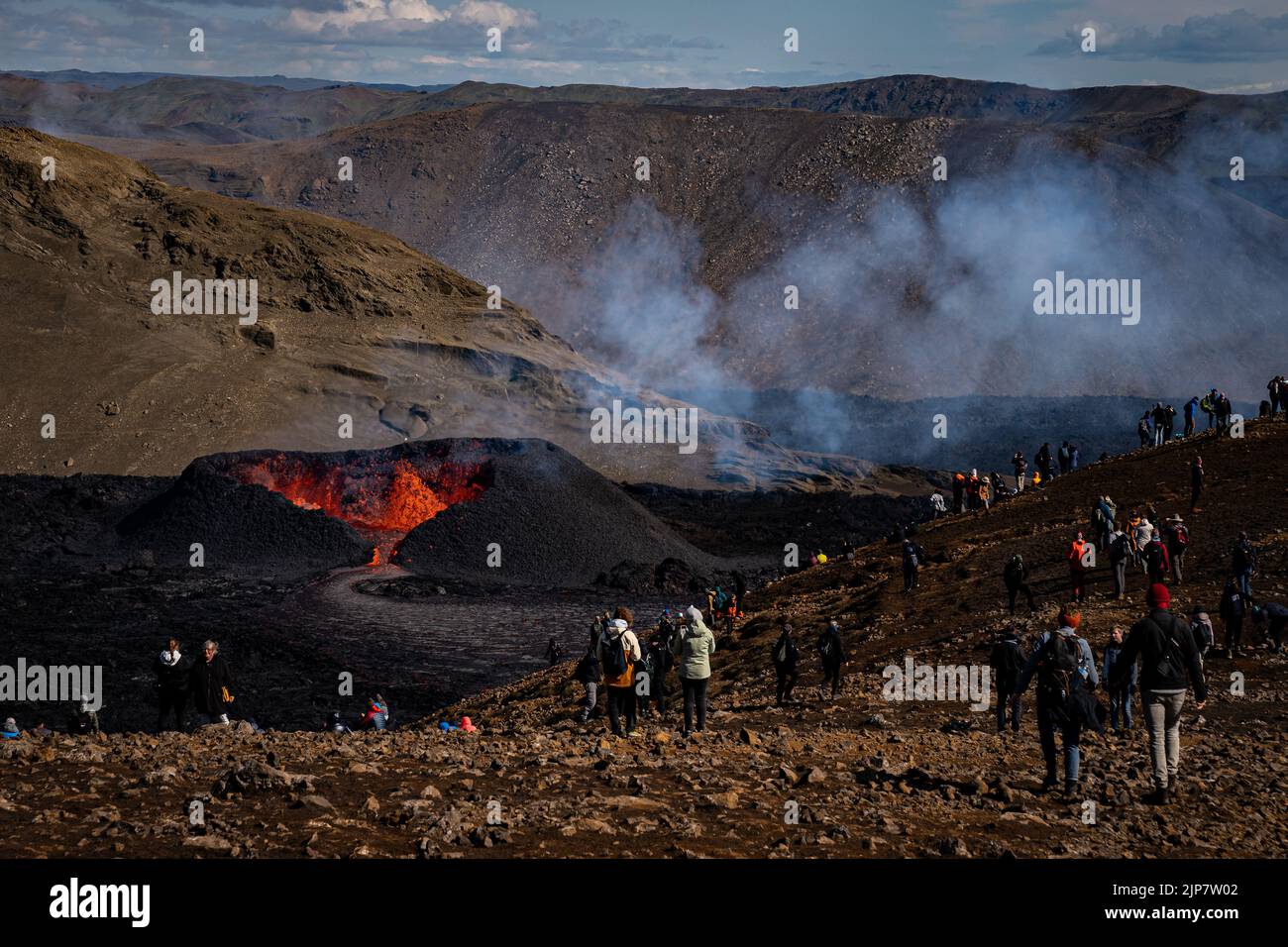 Tourists Visit A Heart Shaped Crater As Lava Flows From The Volcano In