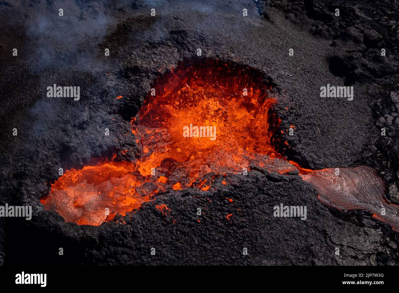 Magma flows from a heart shaped crater at the volcano in Fagradalsfjall ...