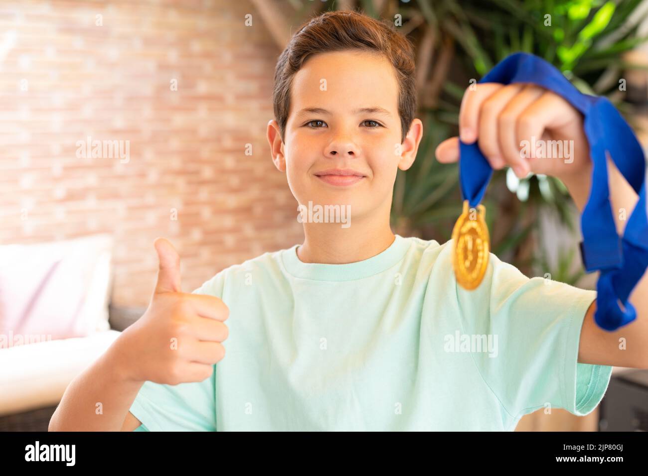 Cute child boy showing his gold medal with thumb up standing on the ...