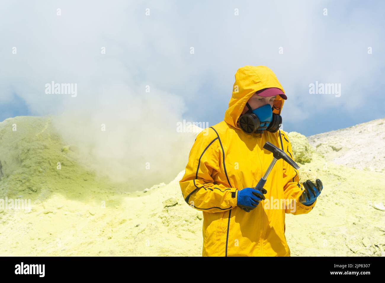female volcano scientist on the background of a smoking fumarole ...