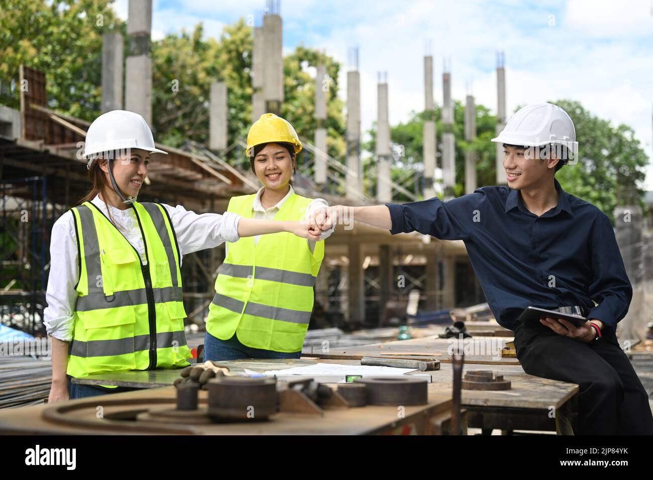 Engineers team wearing safety helmet and vest inspecting industrial building construction site ...
