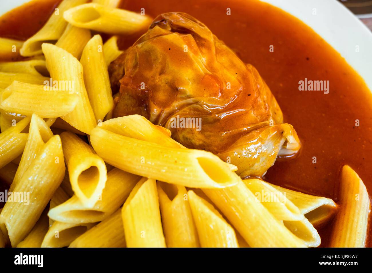 Baked stuffed yellow pepper with meat and boiled penne pasta ale dente ...