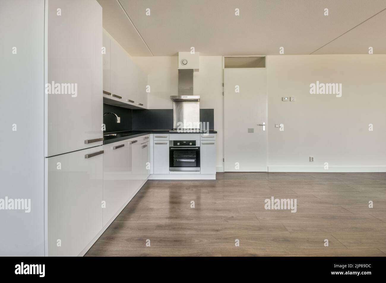 Interior of empty white kitchen with windows and wooden parquet floor ...