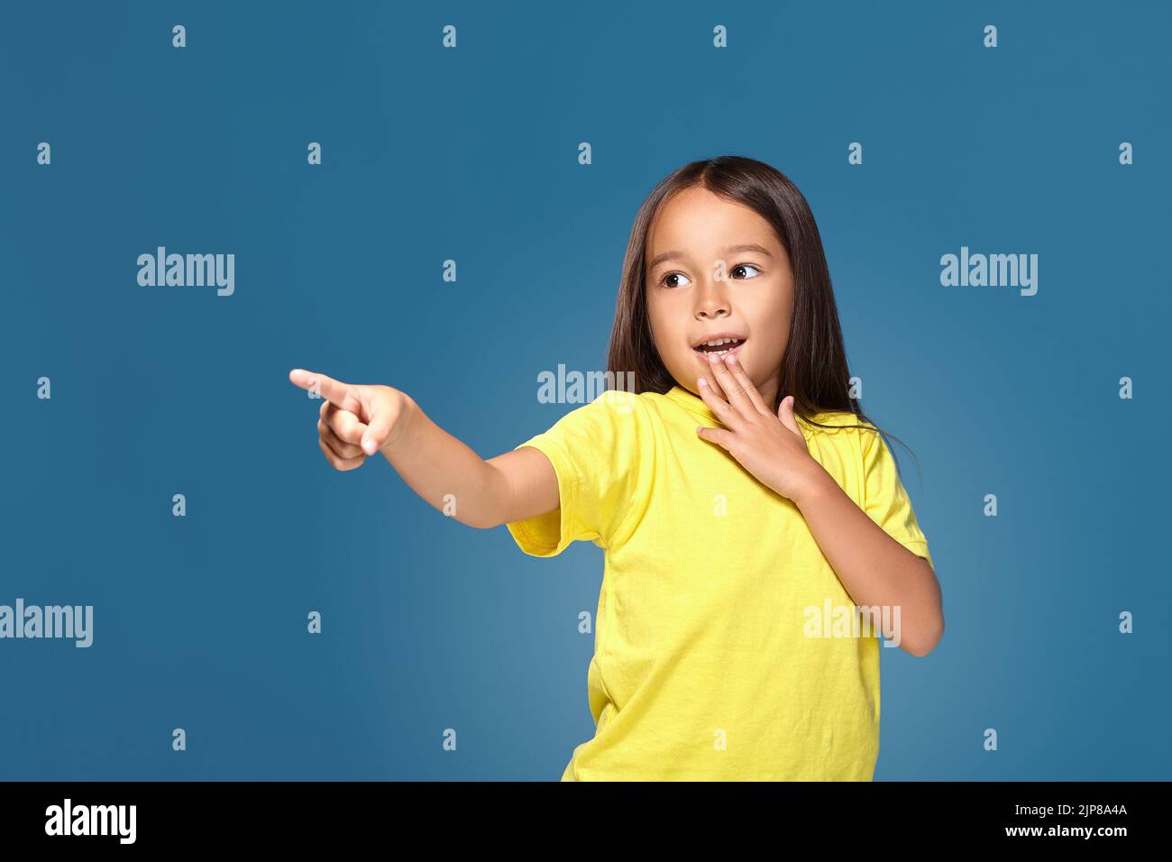 Cute girl shows finger on blue background Stock Photo - Alamy