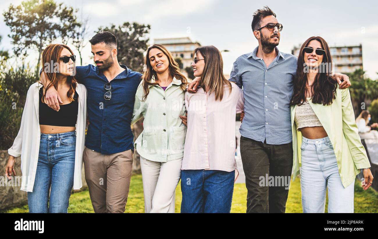 Young friends walking hugging in the city park - young people standing ...
