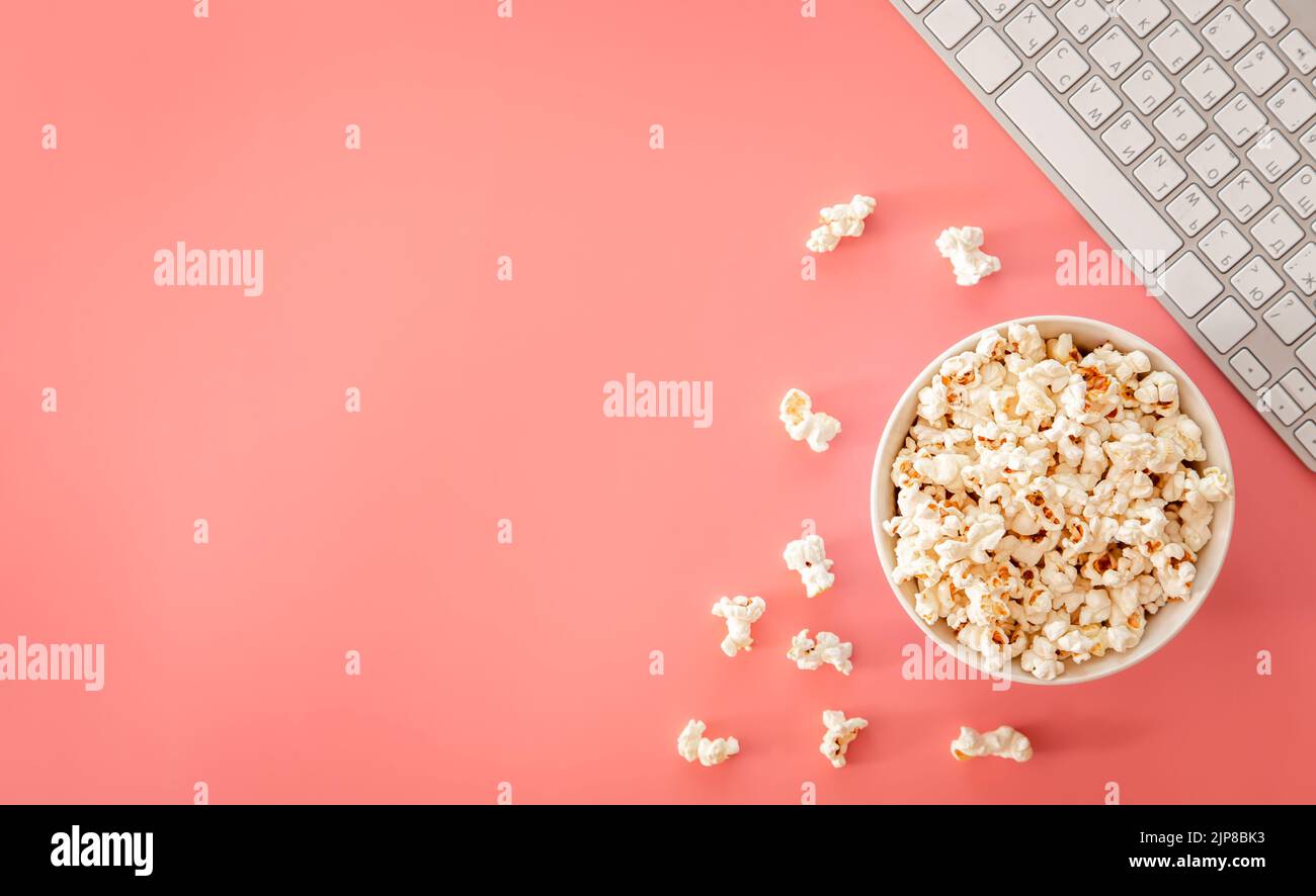 Popcorn and keyboard on pink background, flat lay Stock Photo - Alamy