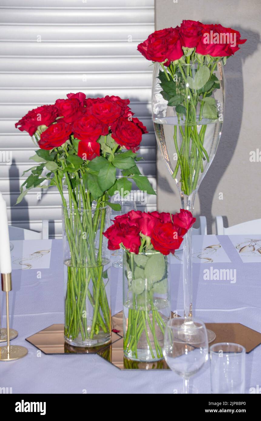 Bouquet of red roses decorates a table at a festive celebration and ...
