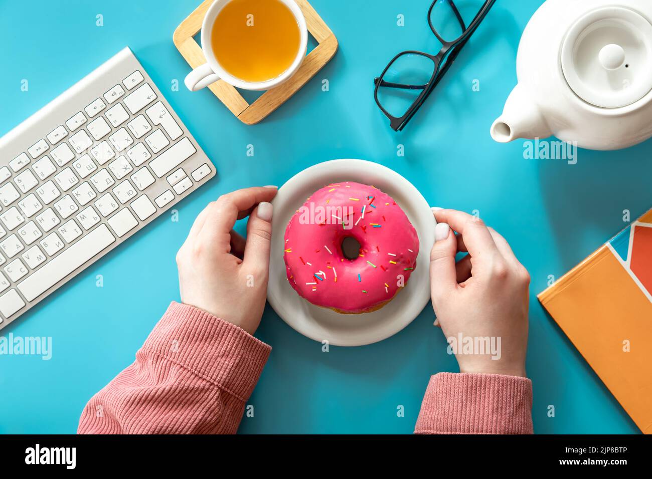 Donut, tea and keyboard on a blue background, flat lay Stock Photo - Alamy