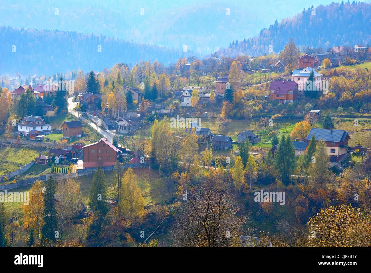 Aerial view of an autumn small village in a valley and mountains in a ...